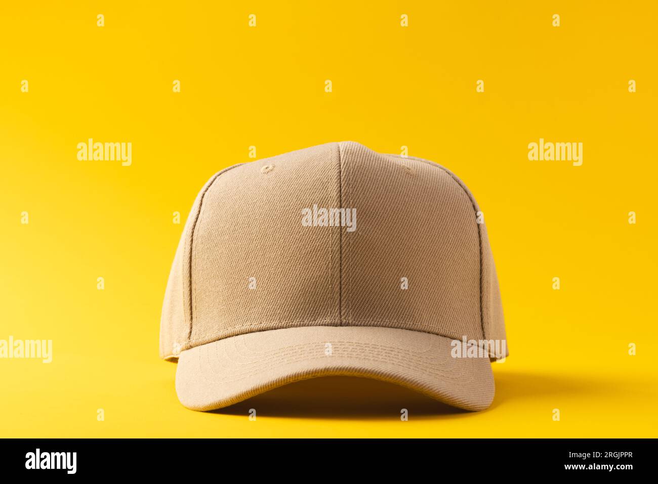 Cream baseball cap and copy space on yellow background Stock Photo - Alamy