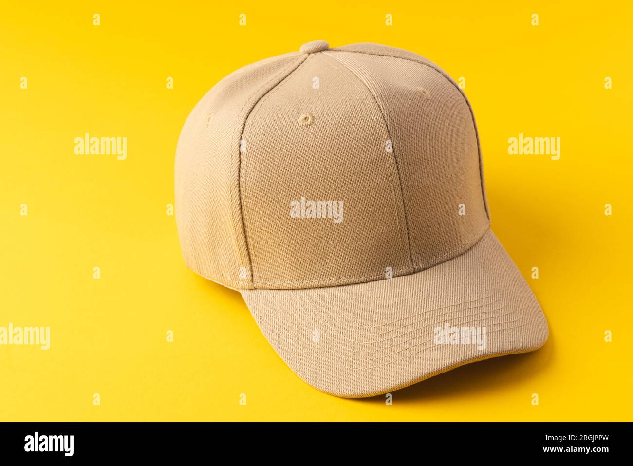 Cream baseball cap and copy space on yellow background Stock Photo - Alamy