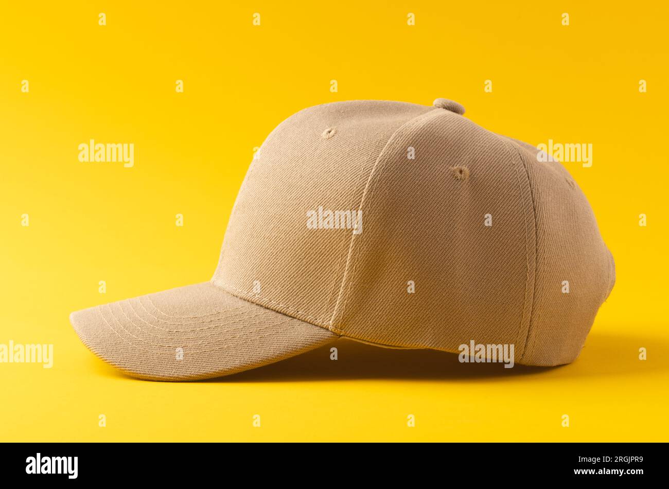 Cream baseball cap and copy space on yellow background Stock Photo - Alamy