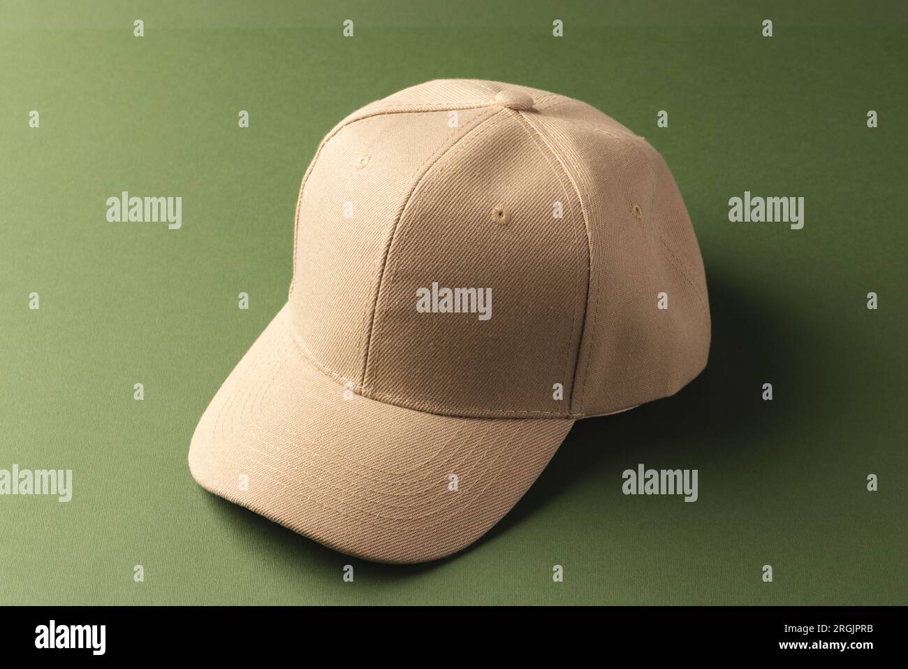 Cream baseball cap and copy space on green background Stock Photo - Alamy