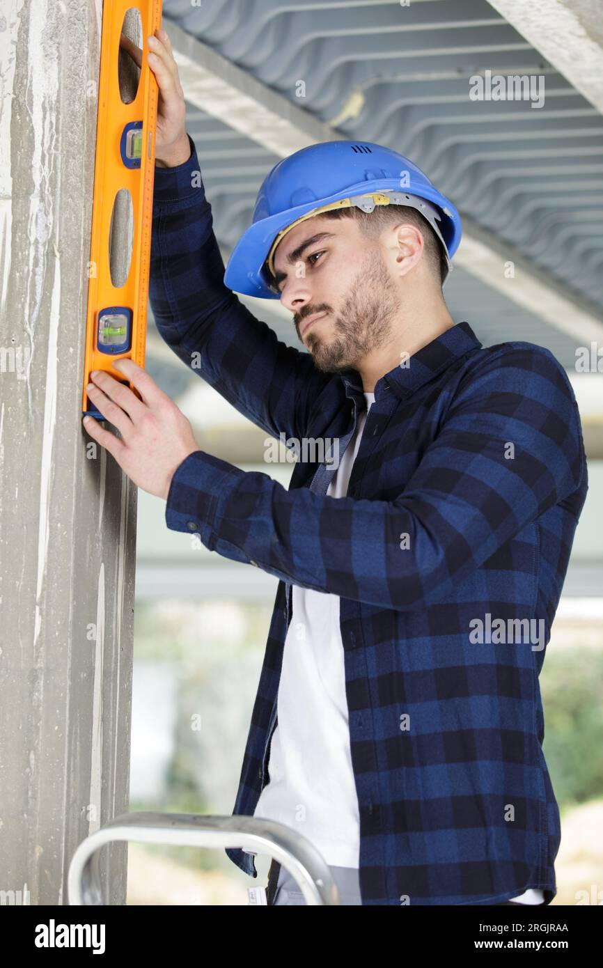 mason checking horizontal level of house wall Stock Photo - Alamy
