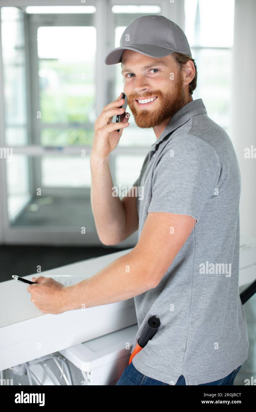 mover guy multitasking with clipboard and phone Stock Photo - Alamy