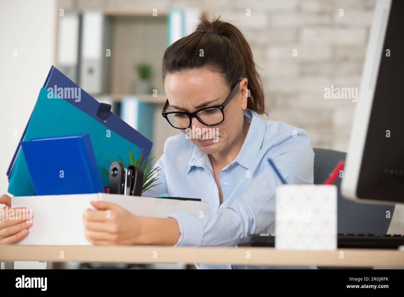redundant woman looking sadly at her box of work possessions Stock ...