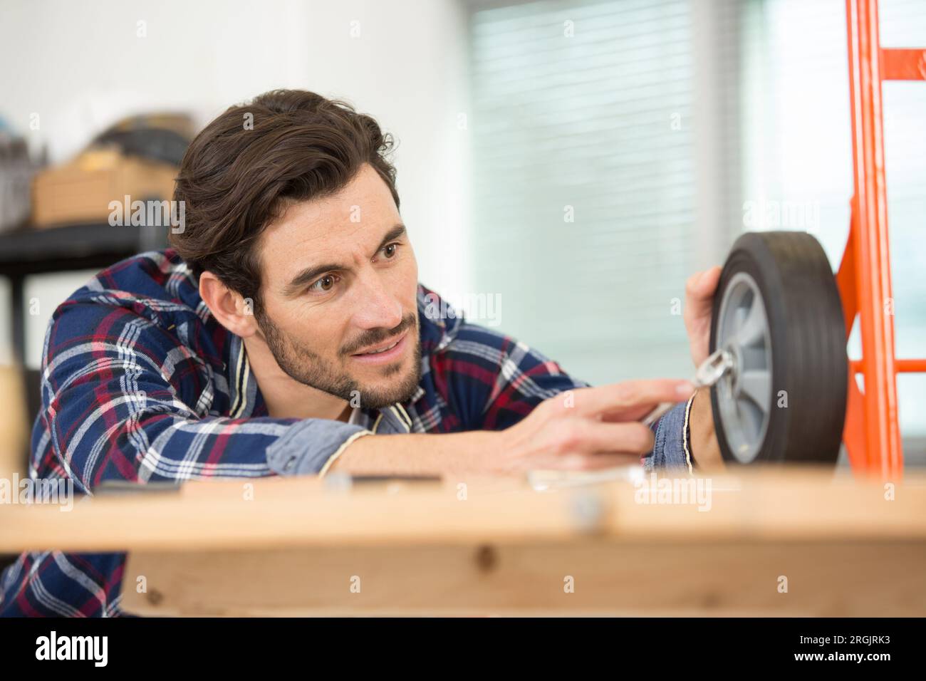 a man fixing a trolley wheel Stock Photo - Alamy