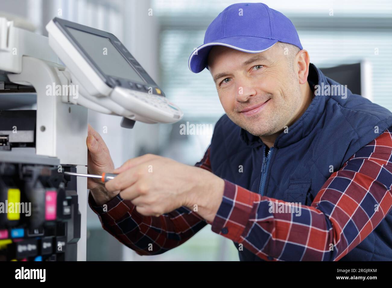 closeup shot young male technician repairing digital photocopier ...