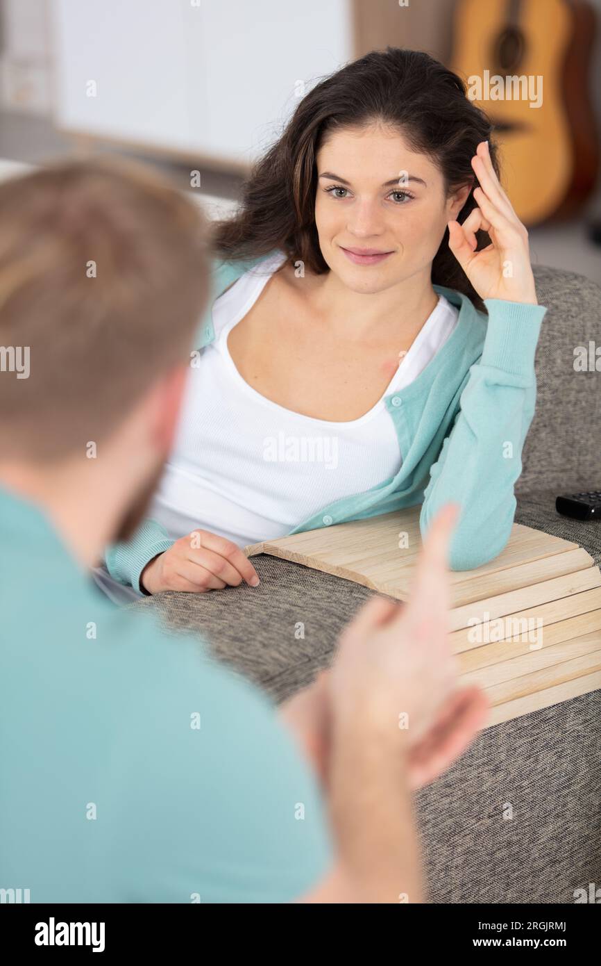 smiling young woman talking using sign language with her boyfriend ...