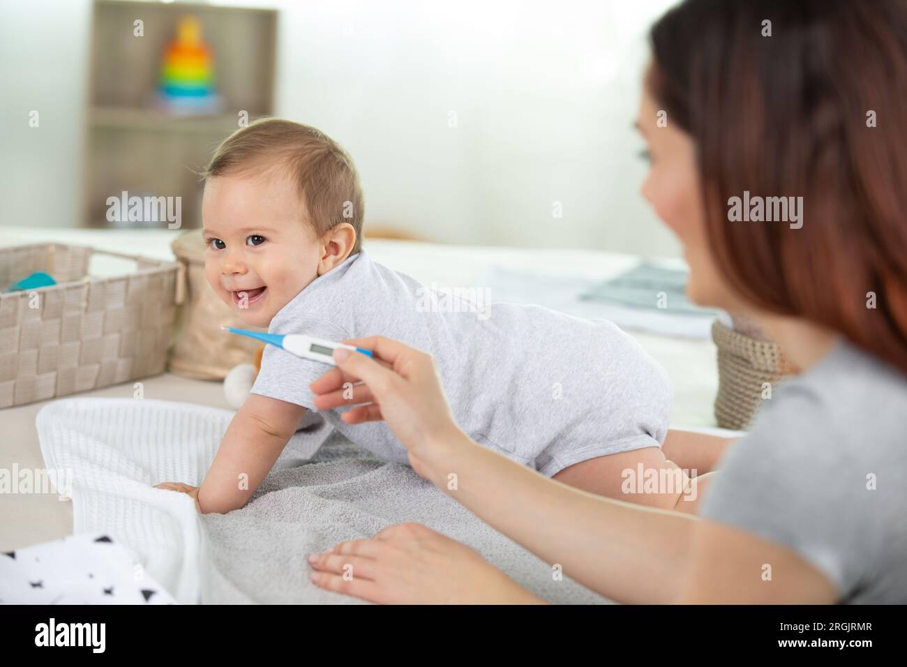 mother measures the temperature of a baby child kid Stock Photo - Alamy