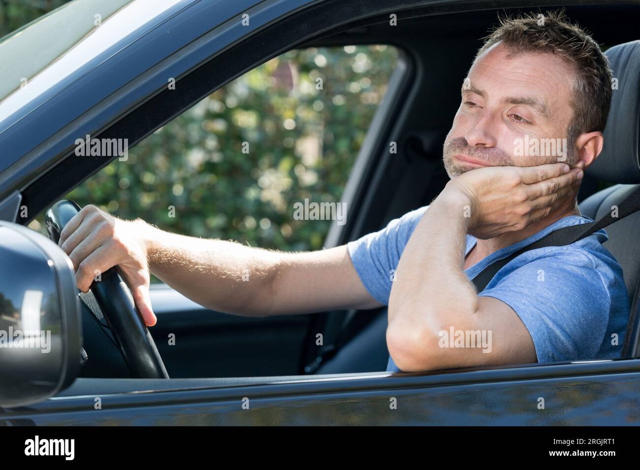 male driver at the wheel sighing in frustration Stock Photo - Alamy