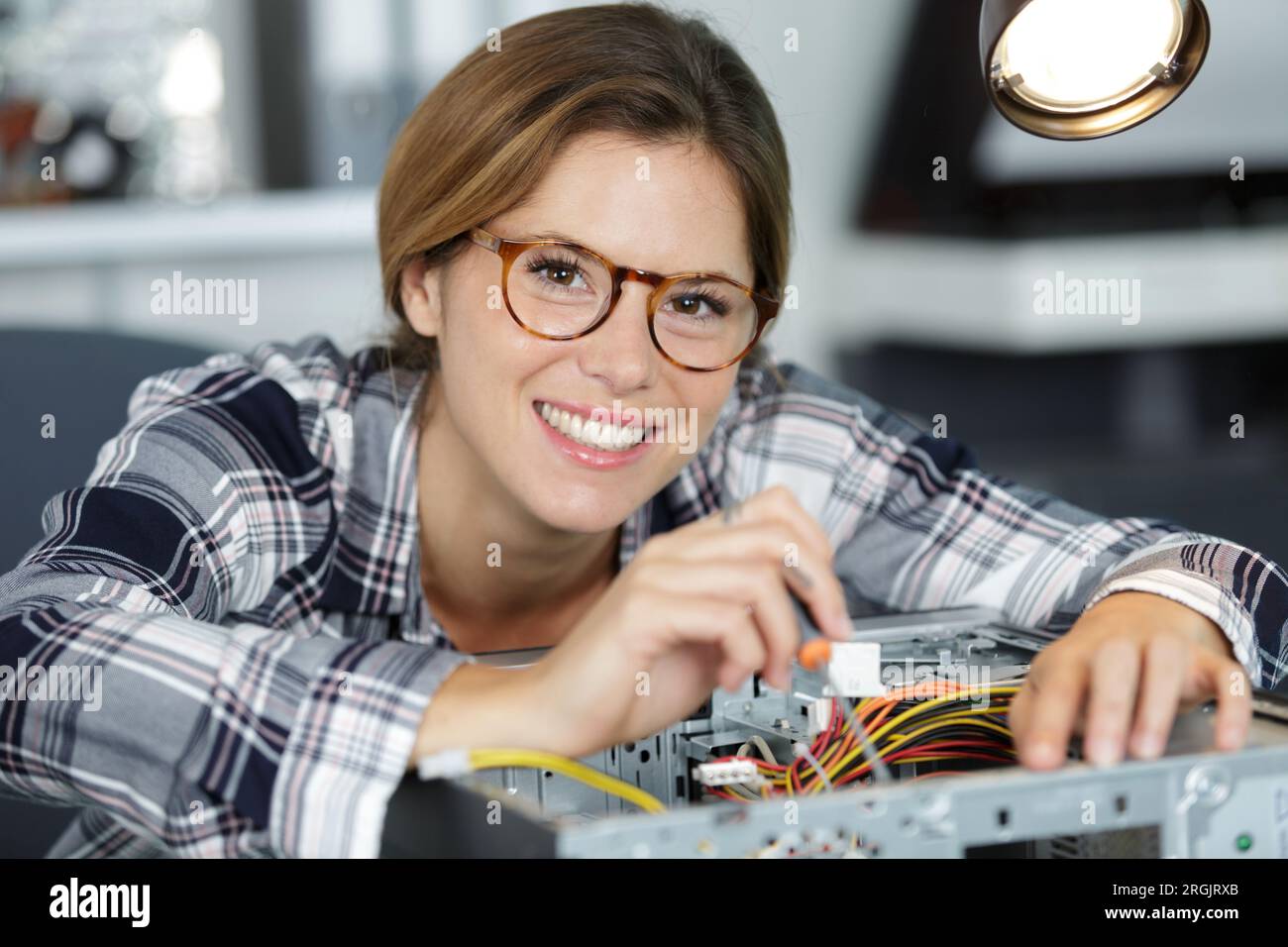 female pc technician posing by a computer Stock Photo - Alamy