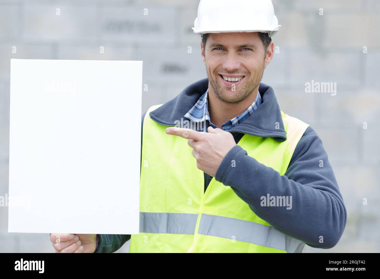 builder - construction worker showinga banner Stock Photo - Alamy
