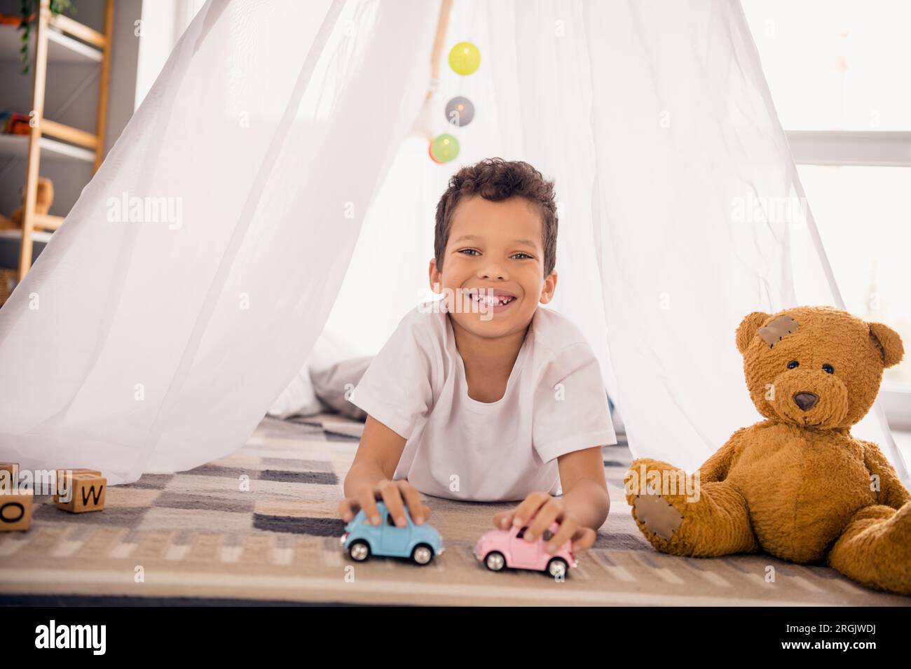 Portrait of nice cheerful cute little boy build camping tent fort play ...