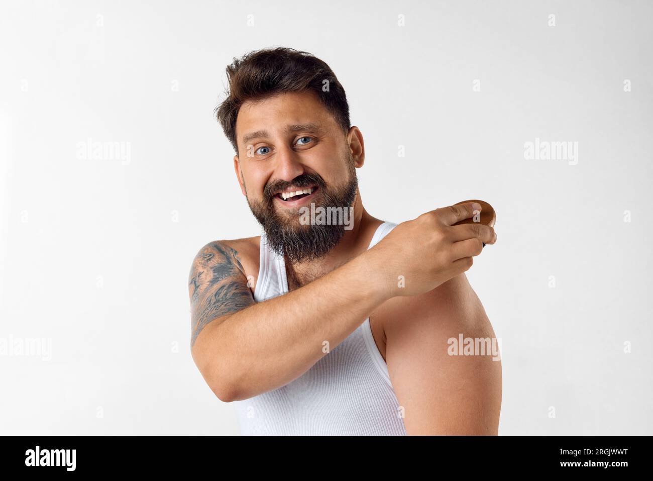 Delightful, smiling, bearded man in singlet taking care after ...