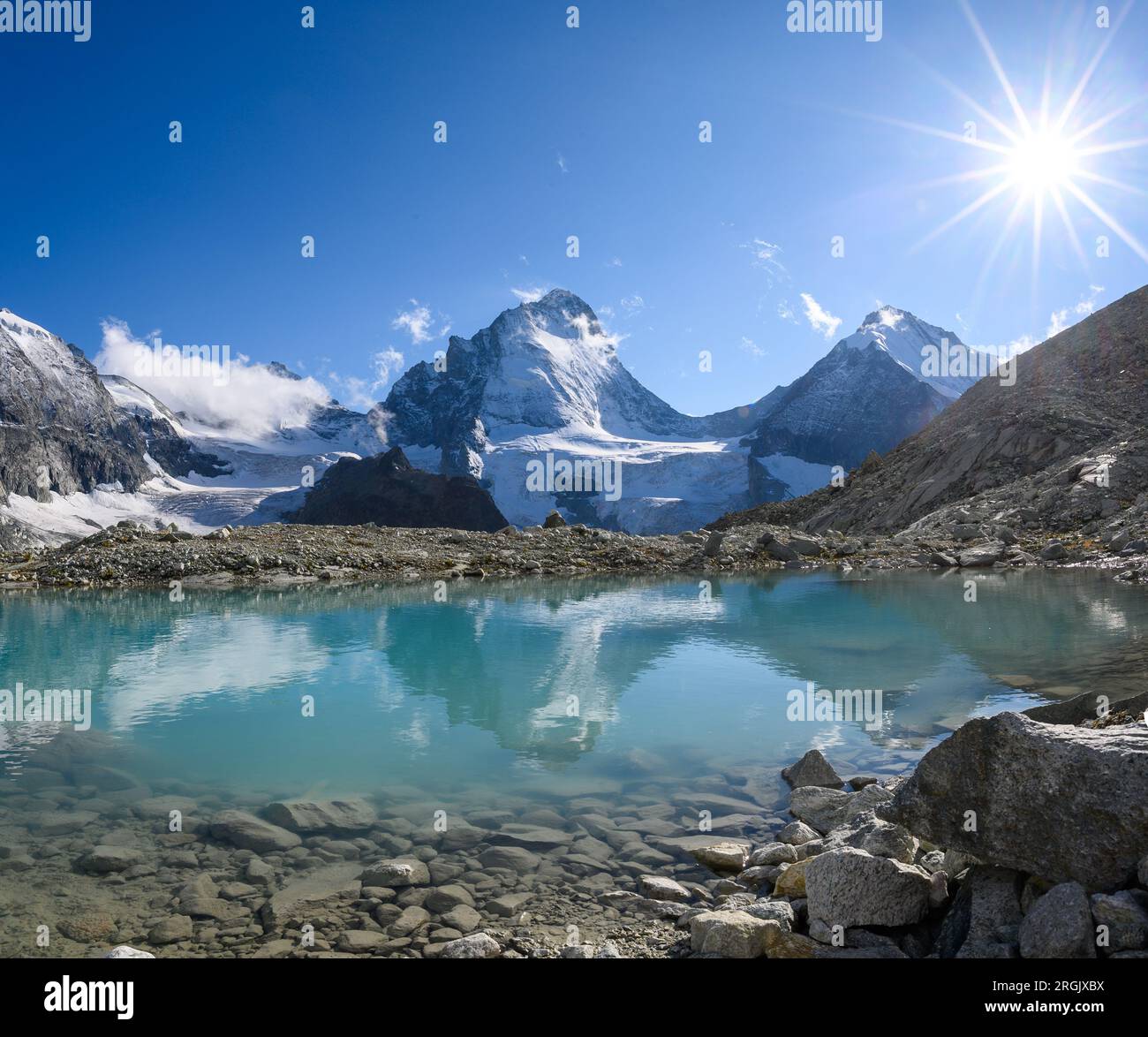 Dent Blanche with sunstar mirroring in an glacier lake Stock Photo - Alamy