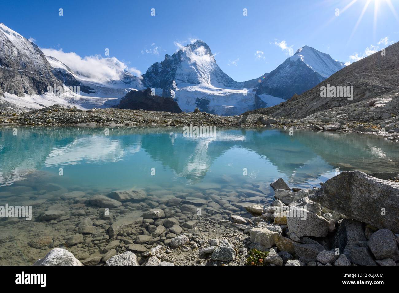 Dent Blanche with sunstar mirroring in an glacier lake Stock Photo - Alamy