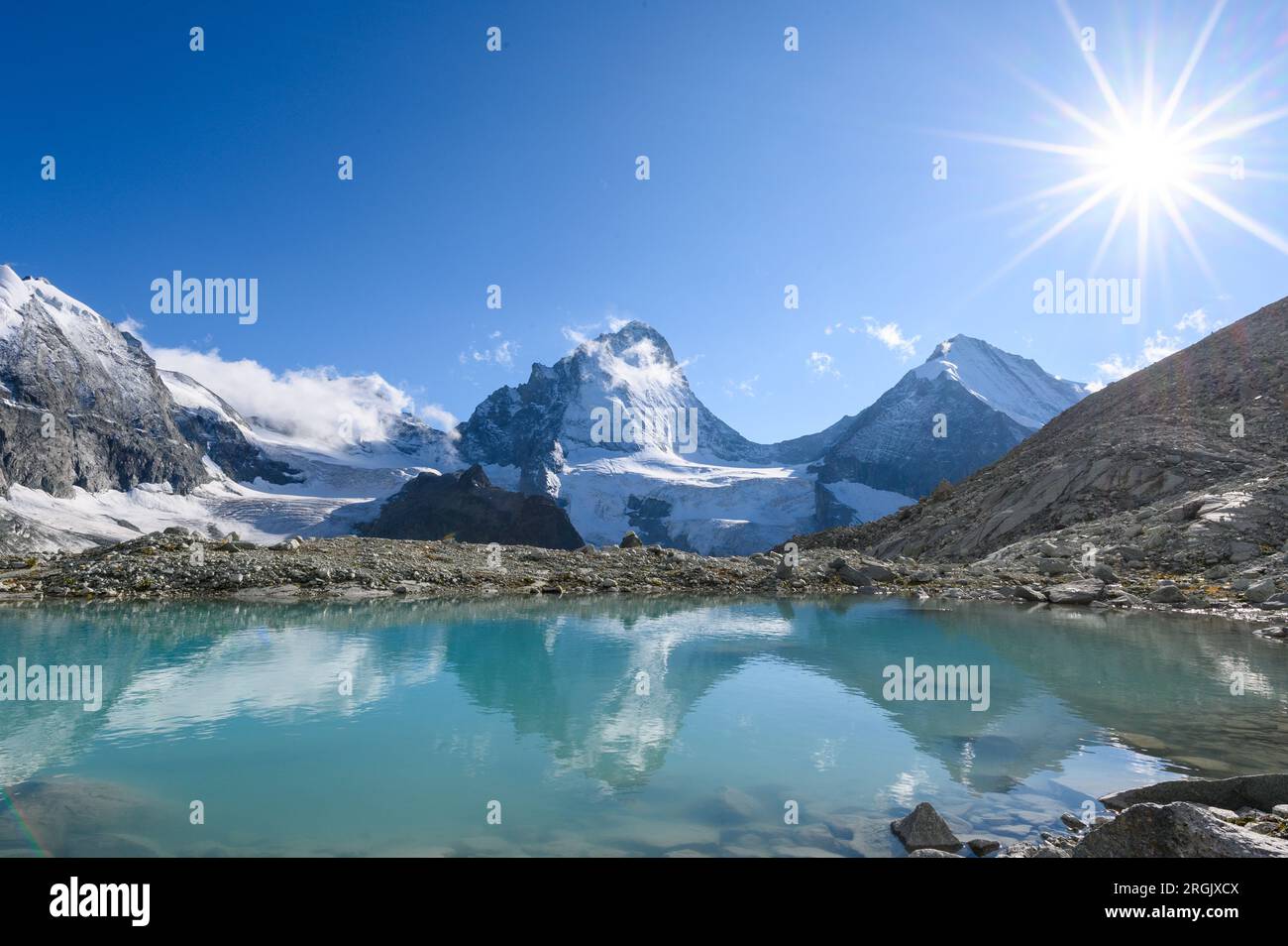 Dent Blanche with sunstar mirroring in an glacier lake Stock Photo - Alamy