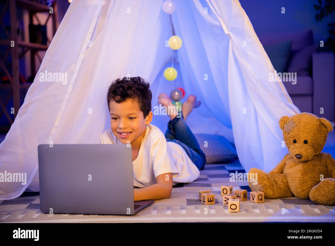 Photo of joyful adorable boy have fun evening weekend watch video on ...