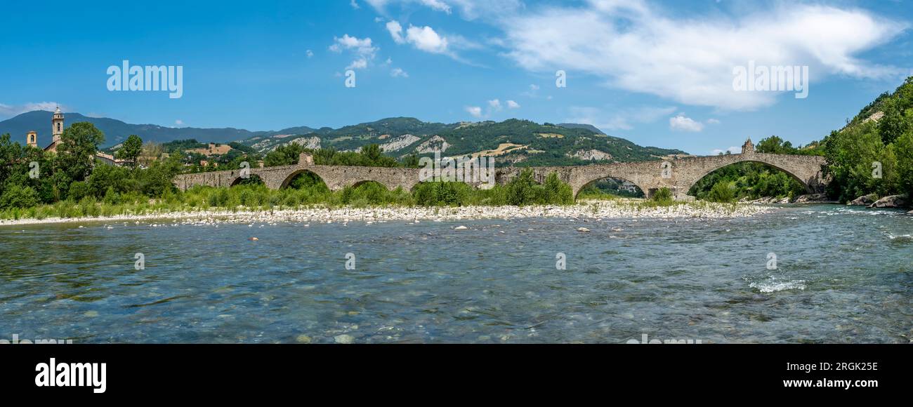 The Trebbia river flows under the ancient Gobbo bridge in Bobbio, Italy ...
