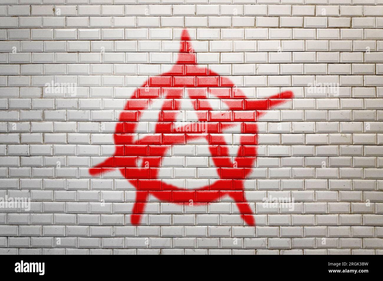Close-up on a red anarchy sign painted on a white faience wall of the ...