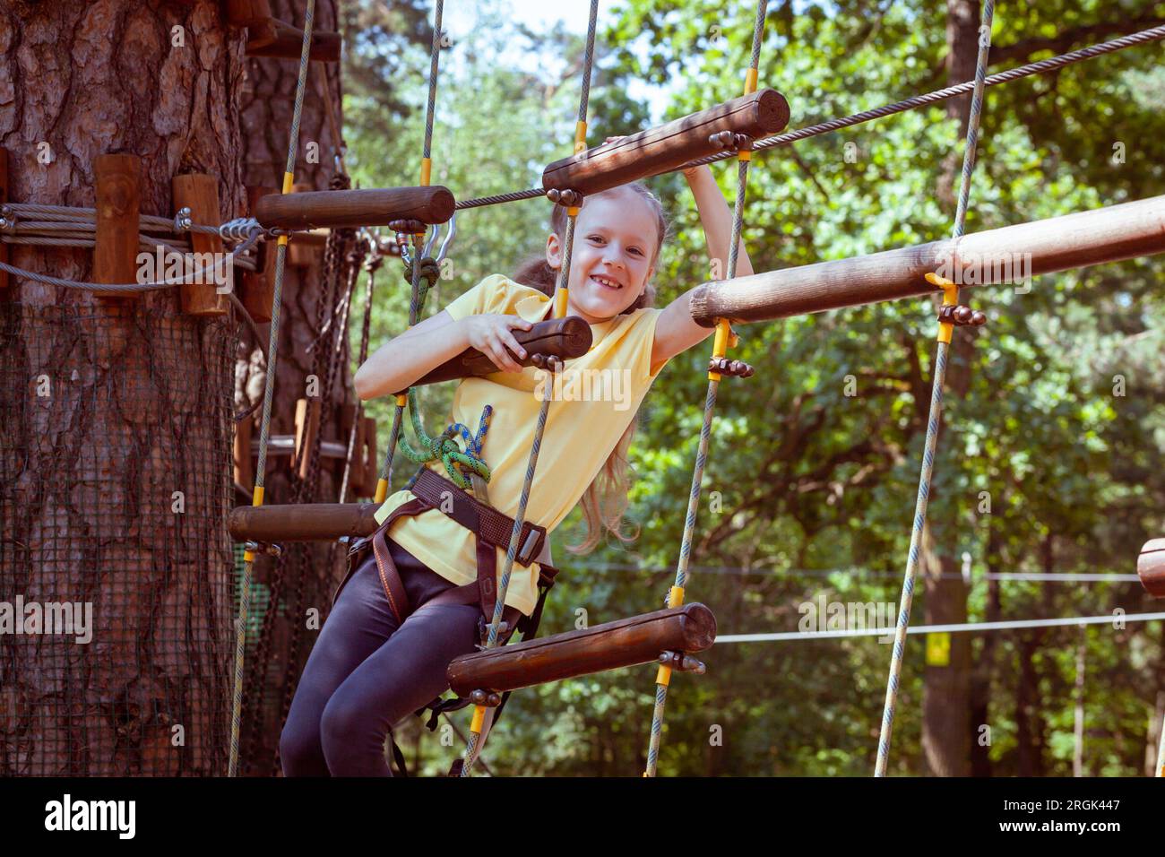 Child in a forest adventure park made of ropes. Children's outdoor ...