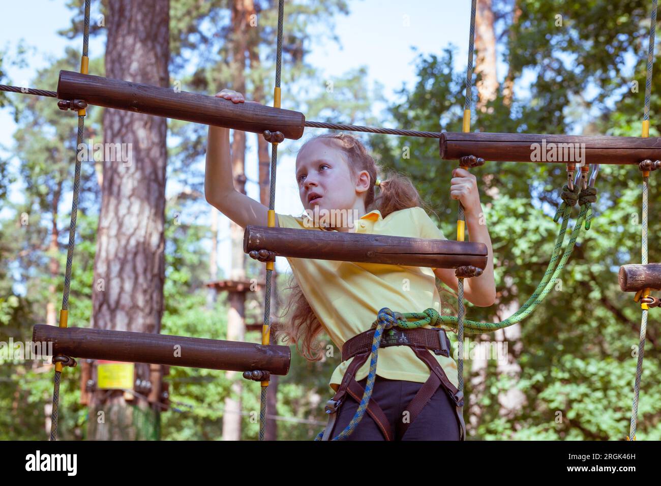 Child in a forest adventure park made of ropes. Children's outdoor ...