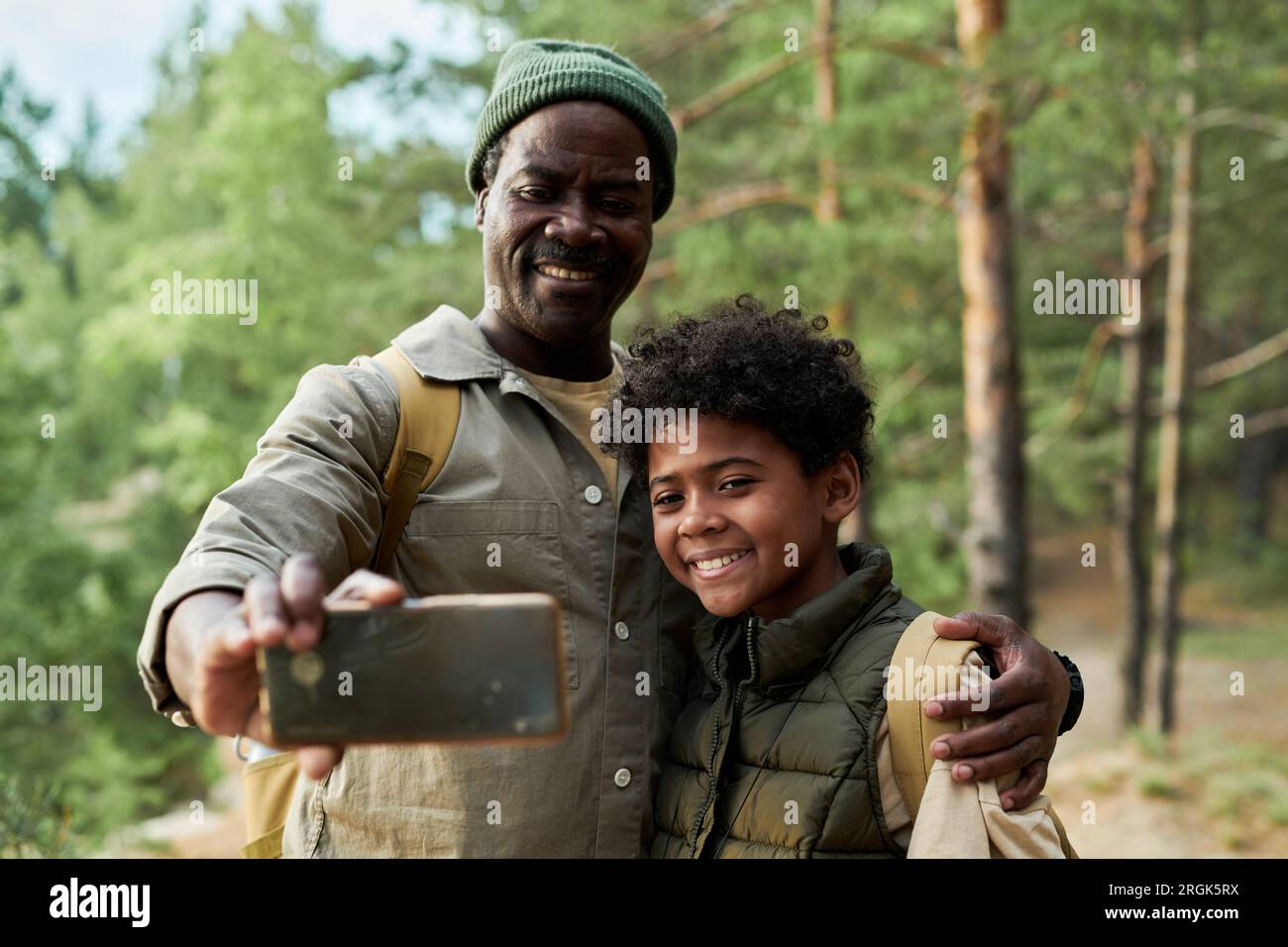 African American dad making selfie portrait with his son on smartphone ...