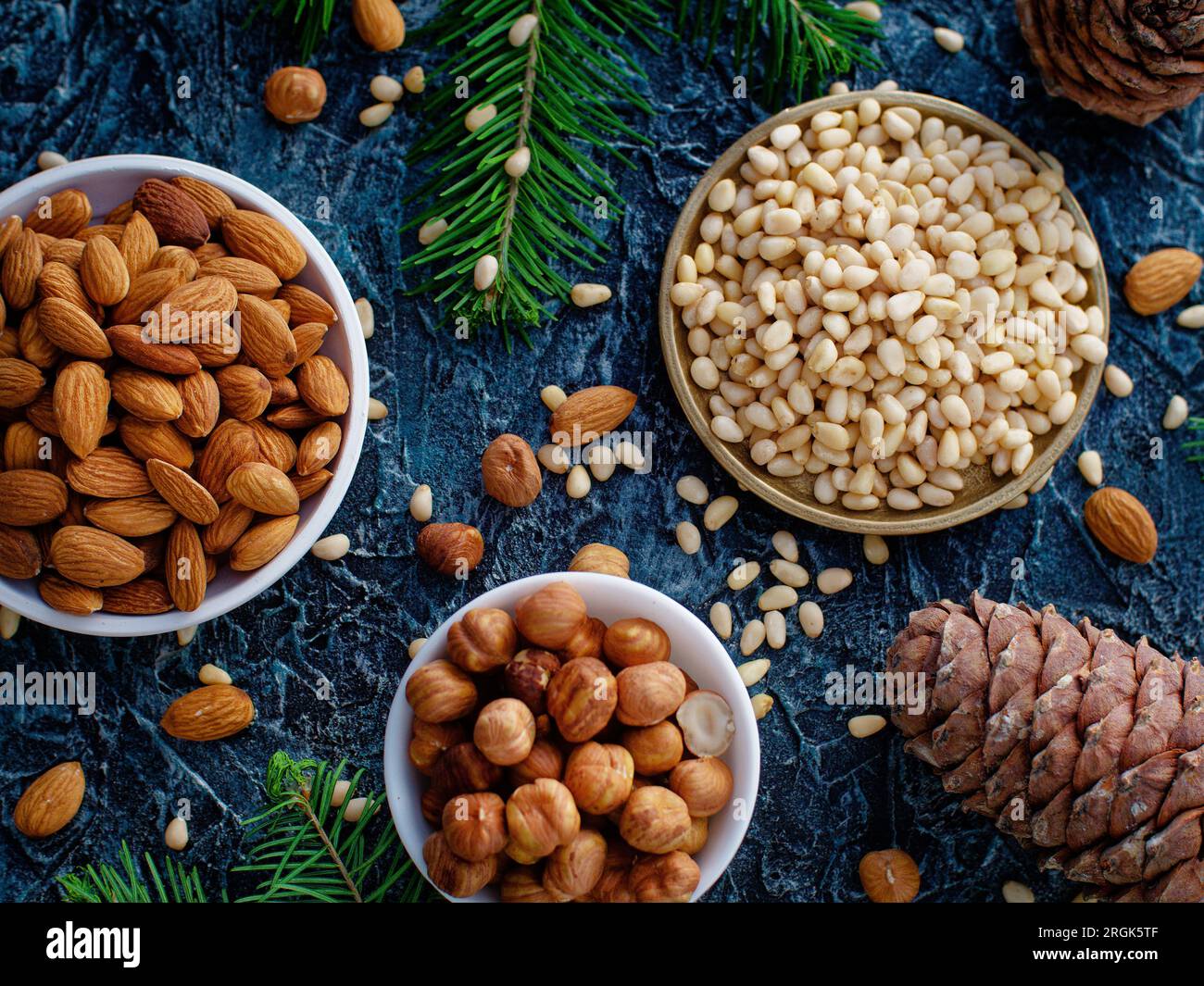 Assorted shelled nuts in bowls. Hazelnuts, almonds and pine nuts. Still ...