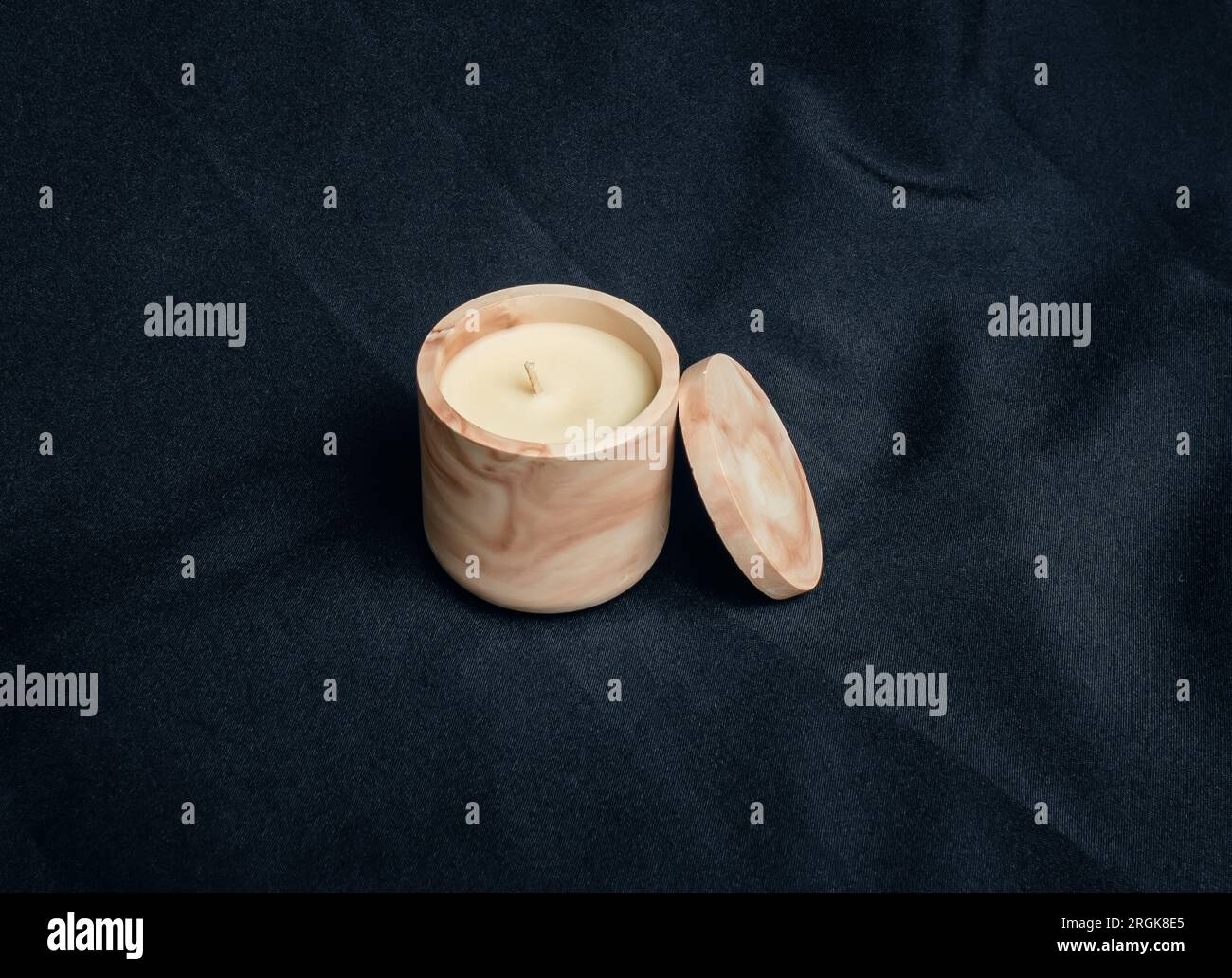 Decorative candle in plaster case. Black background Stock Photo - Alamy