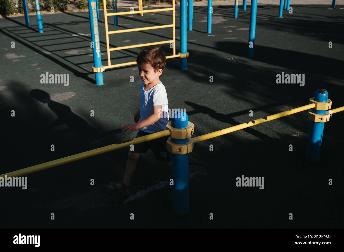 preschool child boy plays on horizontal bars on the playground in the ...