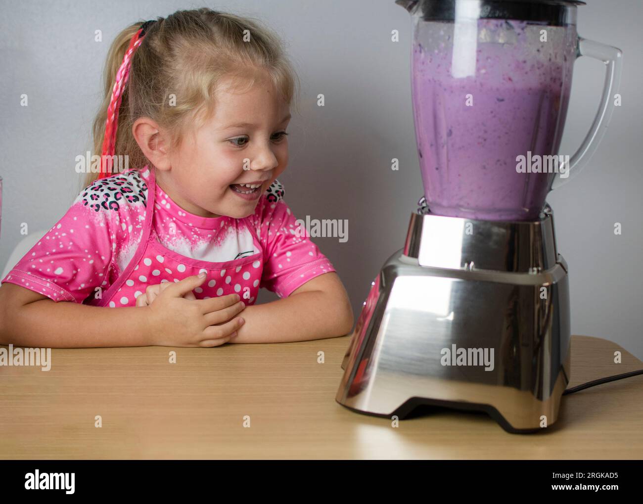 The happy Caucasian cute child is amused by the loud sound of the ...