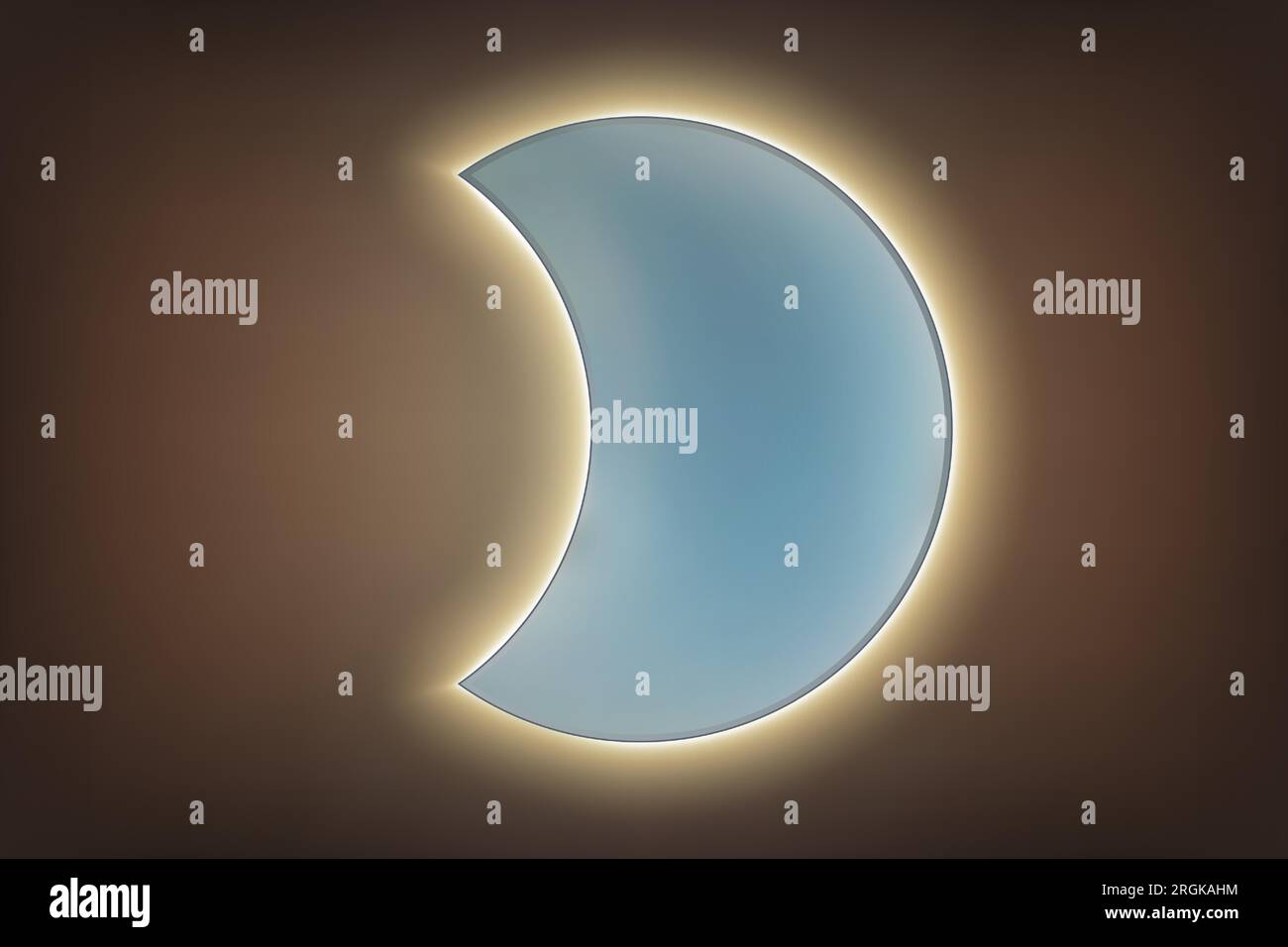 Wall mirror in the shape of a partial moon with yellow backlight on a ...