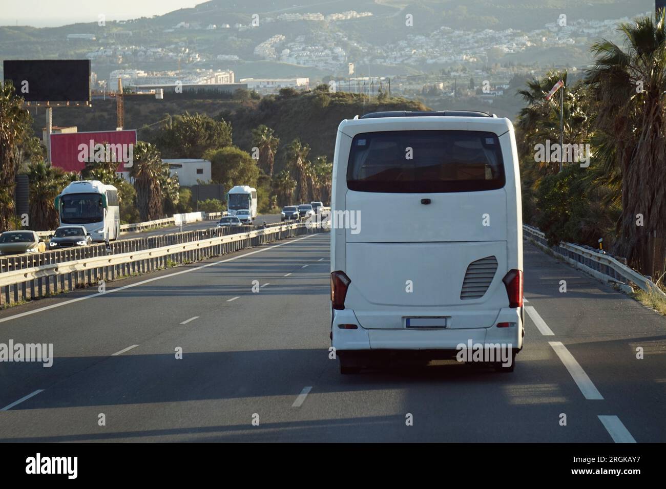Tourist bus on a highway - back view Stock Photo - Alamy