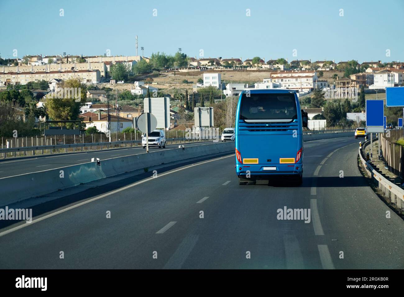Tourist bus on a highway - back view Stock Photo - Alamy