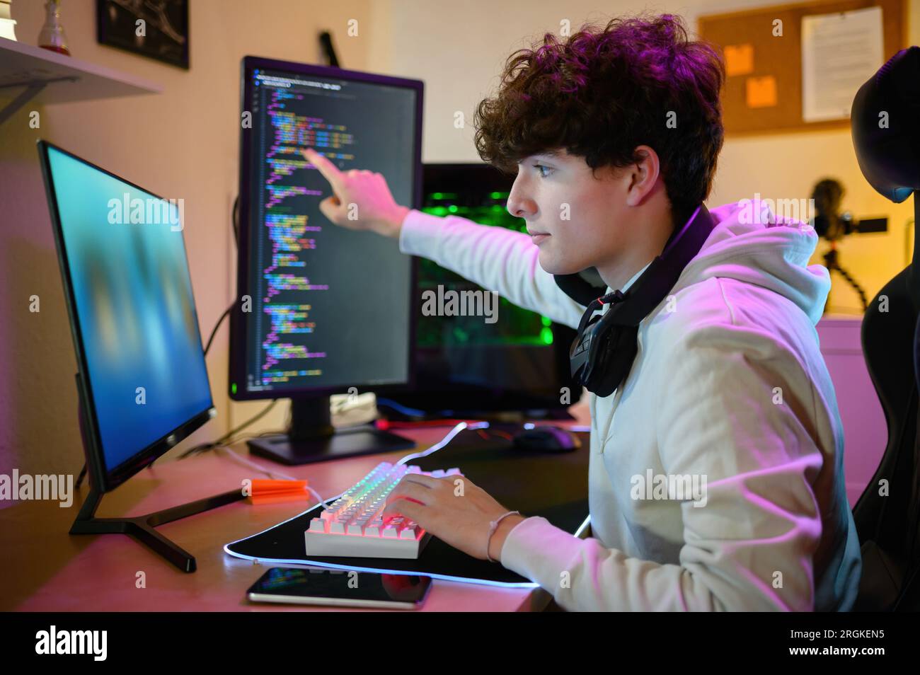 Side view of focused young male looking at screen of monitor with ...