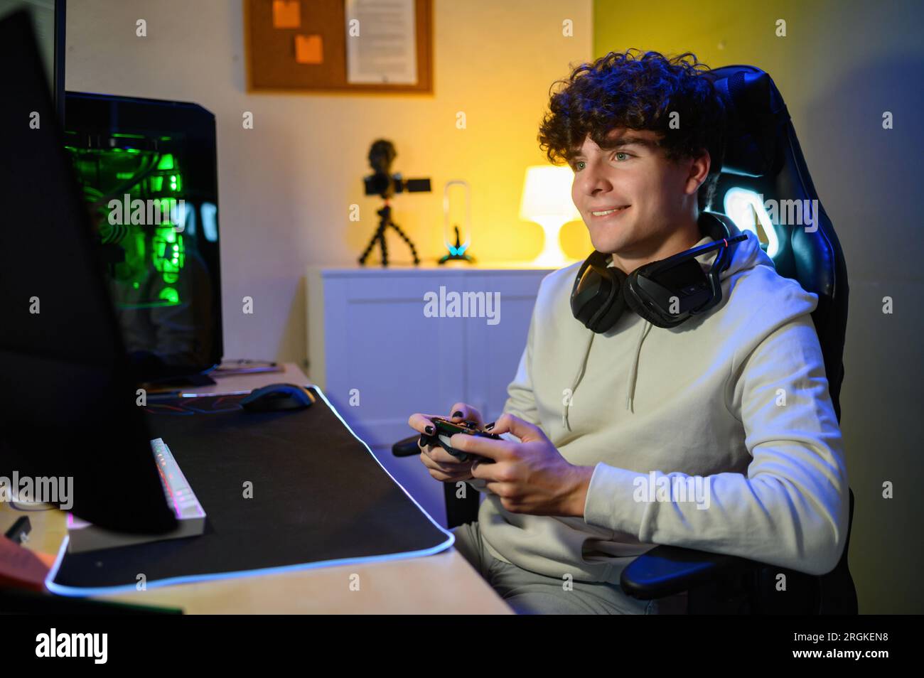 Focused smiling young male looking at screen of computer while sitting ...
