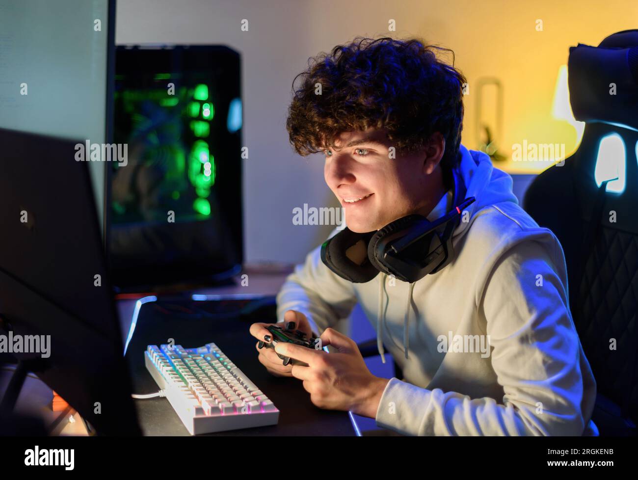Focused smiling young male looking at screen of computer while sitting ...