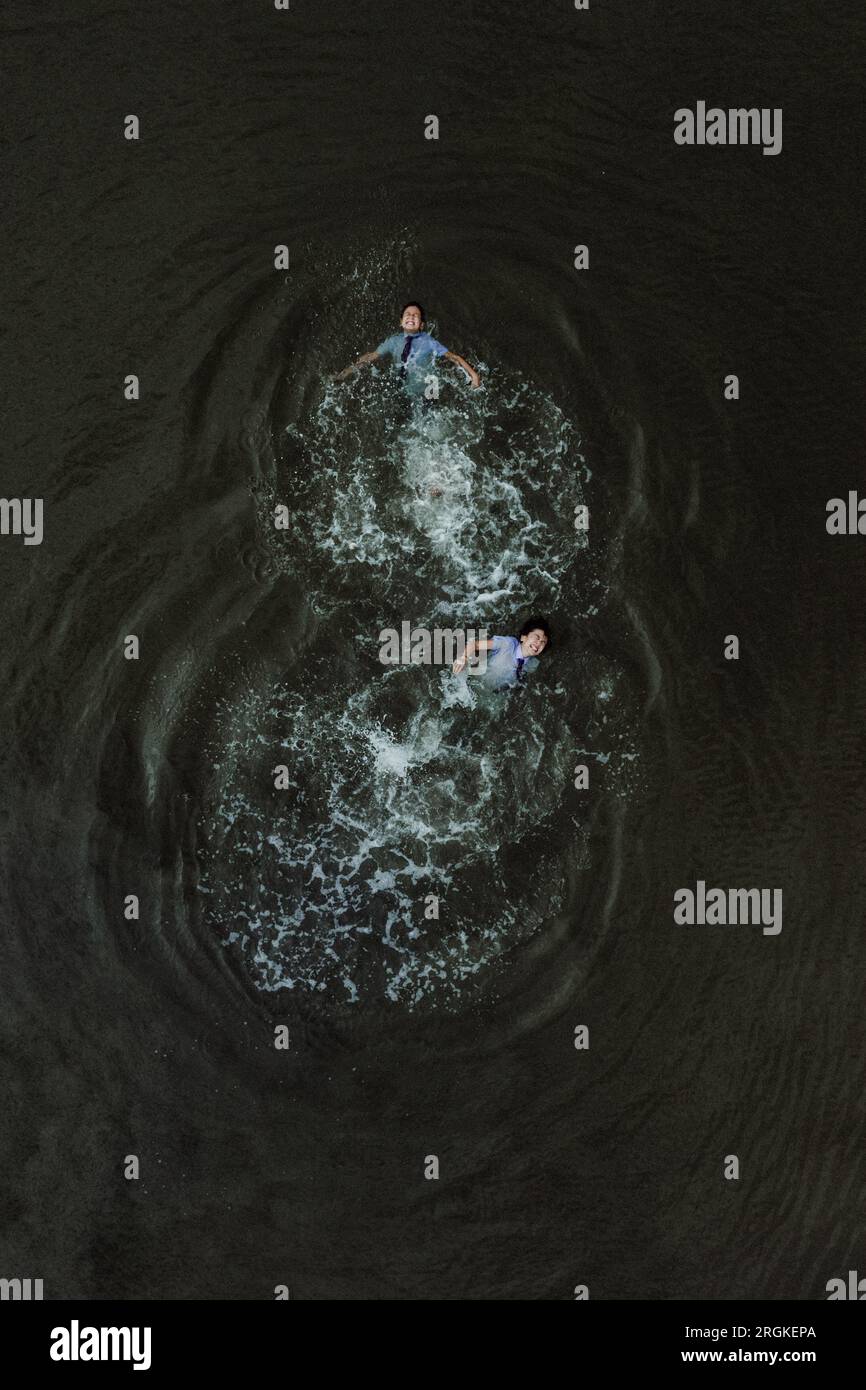 Top view of anonymous cheerful male students in school uniform swimming ...