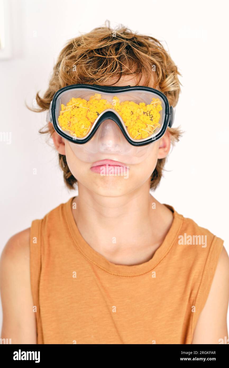 Child with brown hair in undershirt and diving goggles with yellow ...