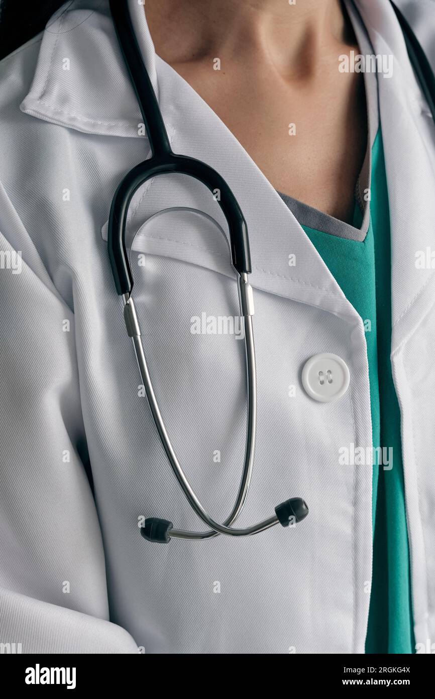 Crop unrecognizable female doctor in white medical robe with button and ...