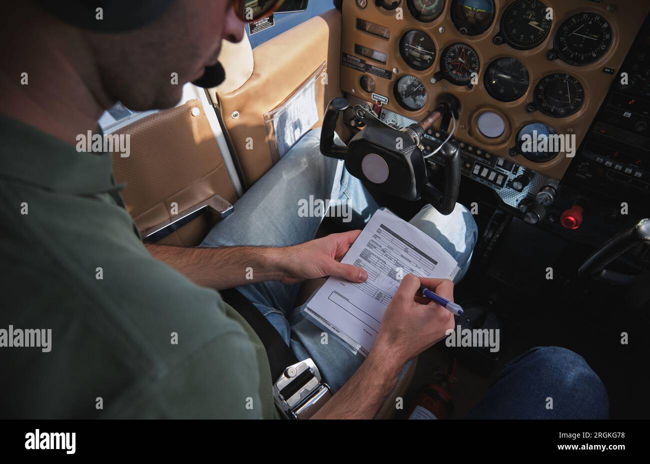High angle crop attentive male aviator sitting in helicopter first ...