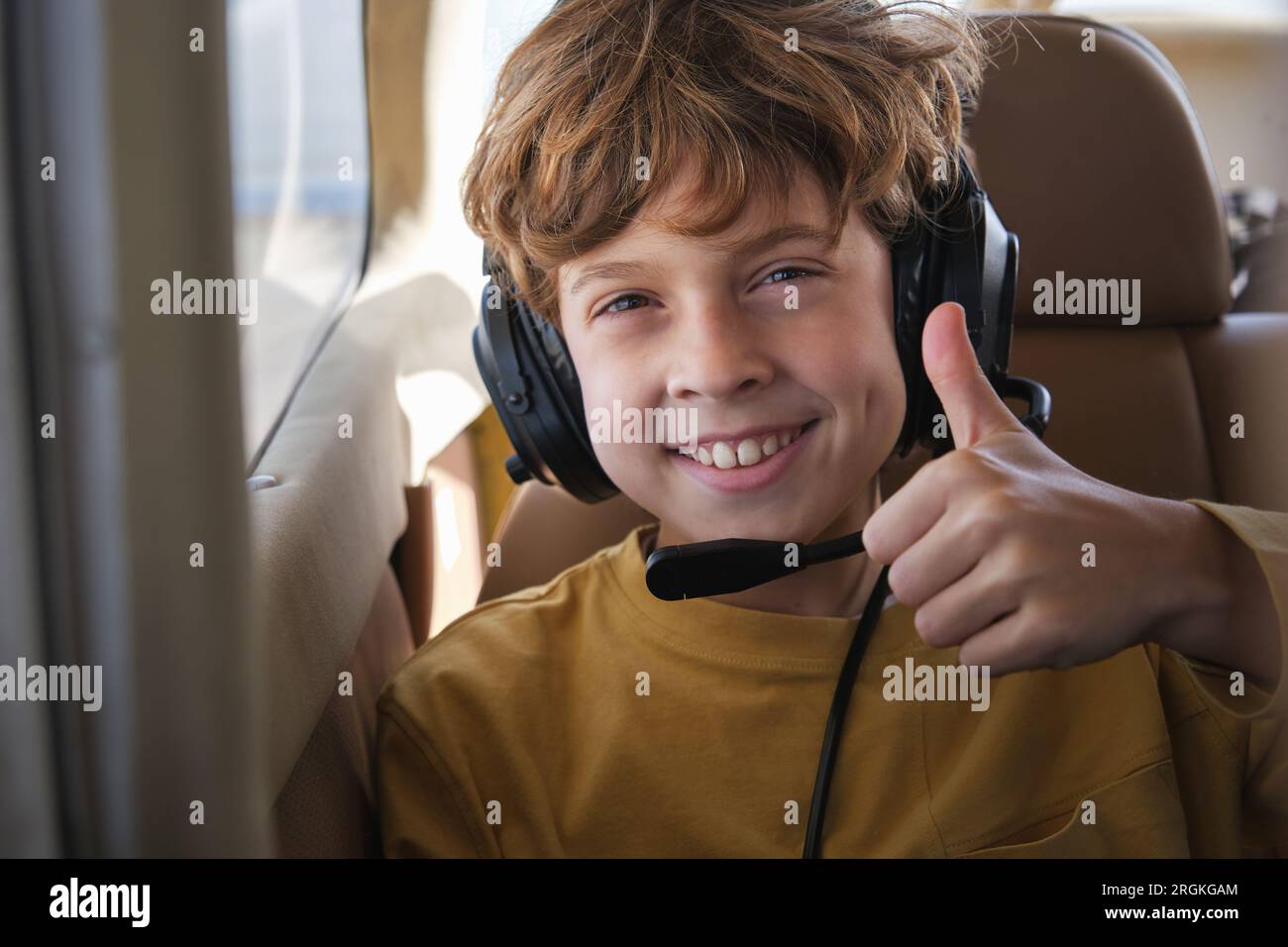 Stock photo of happy young boy wearing aviation headset enjoying light ...