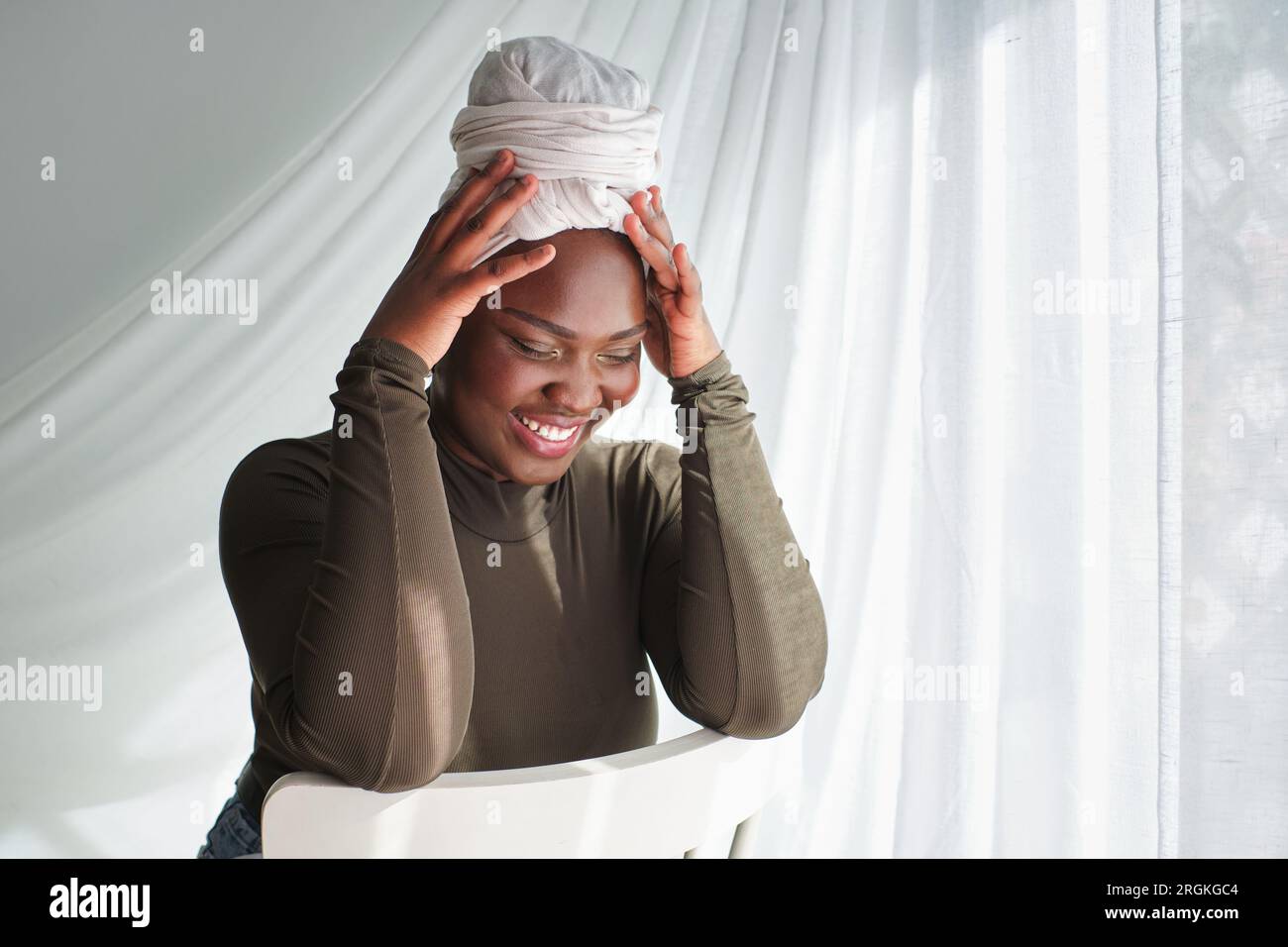Charming Muslim female model in headscarf closing eyes in joy and ...