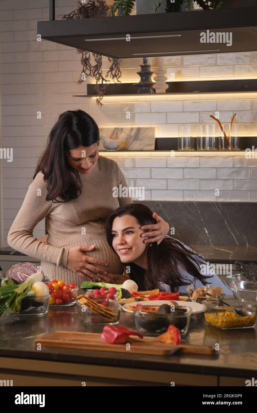 Smiling women bonding while cooking delicious healthy lunch together in ...