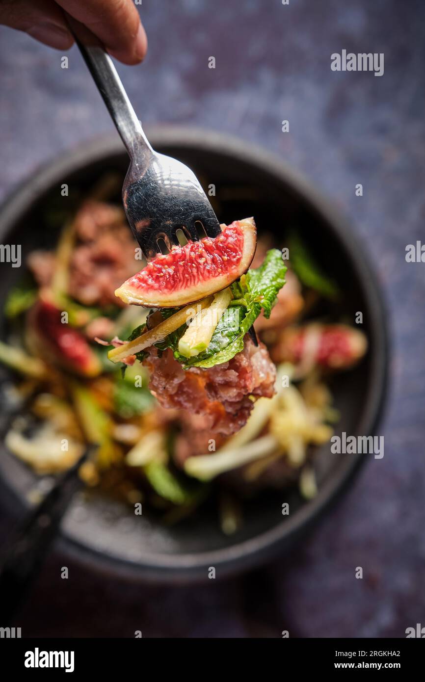 From above of crop anonymous person eating delicious pig trotter with ...