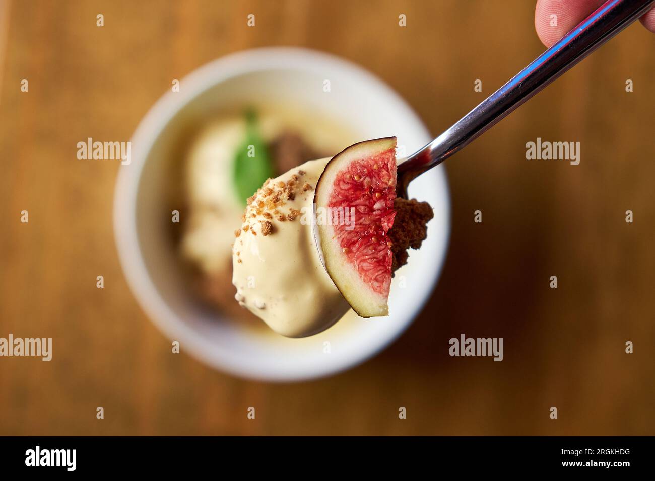 Aerial photo of a spoon with a fig grabbed from a dish of prickly pear ...