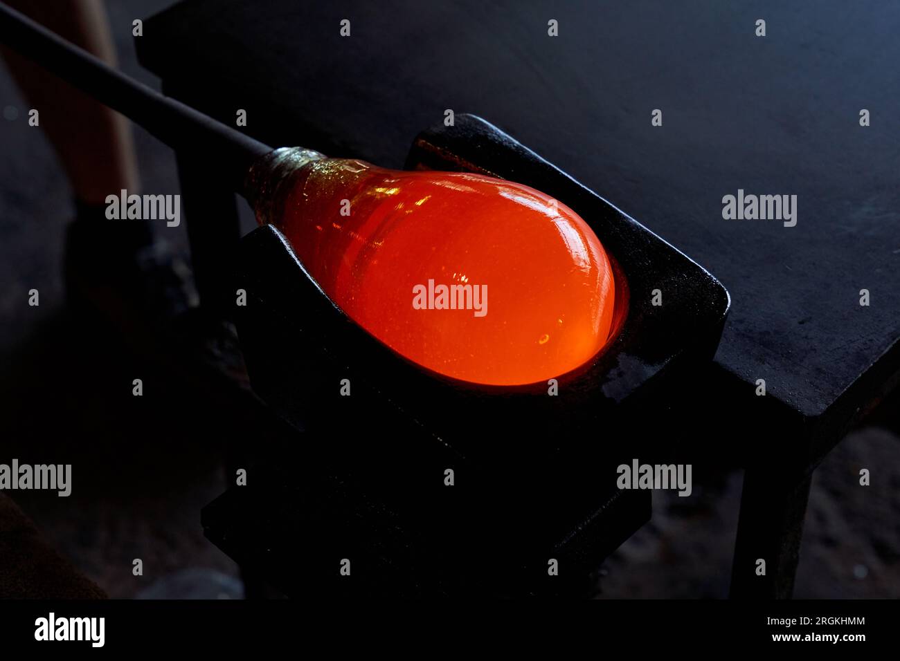 High angle of hot molten glass on tip of pontil in process of making ...