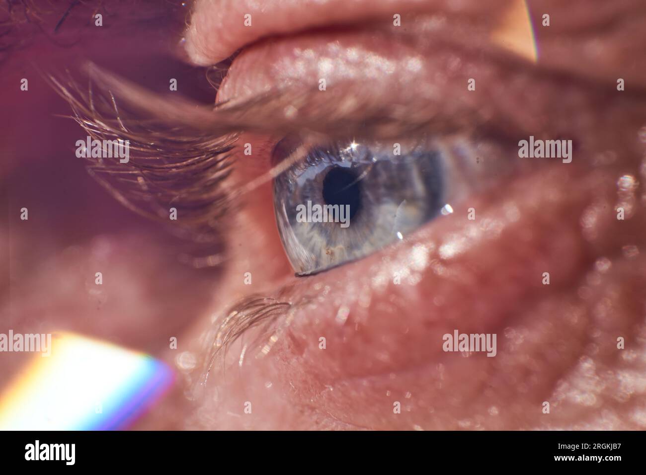 Side view of blue eye of unrecognizable dreamy person with light ...