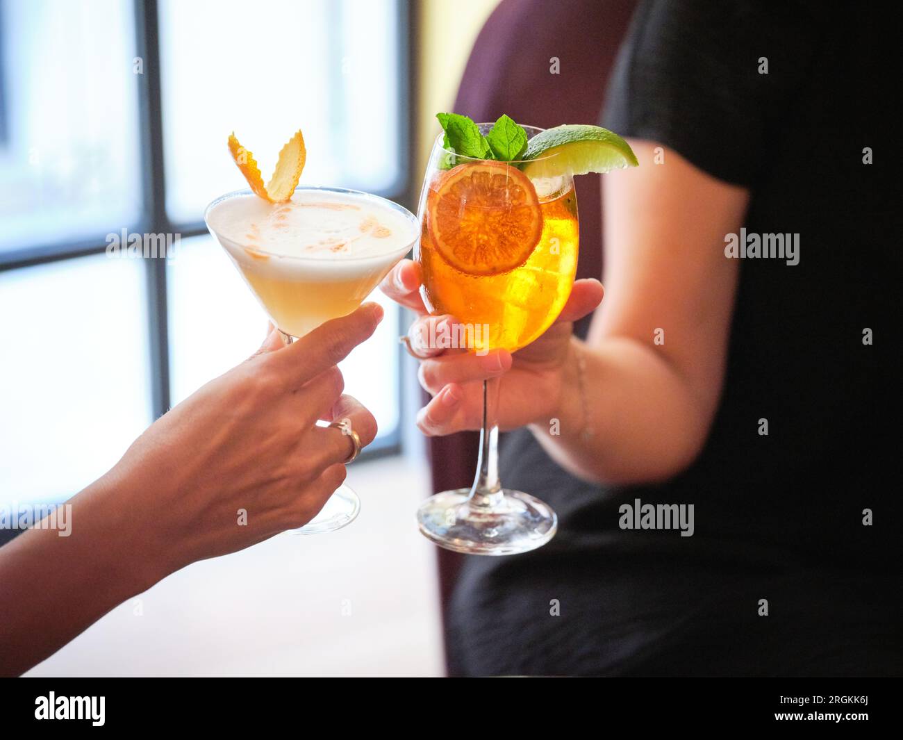 Crop people sitting in restaurant and clinking tropical beverages on ...