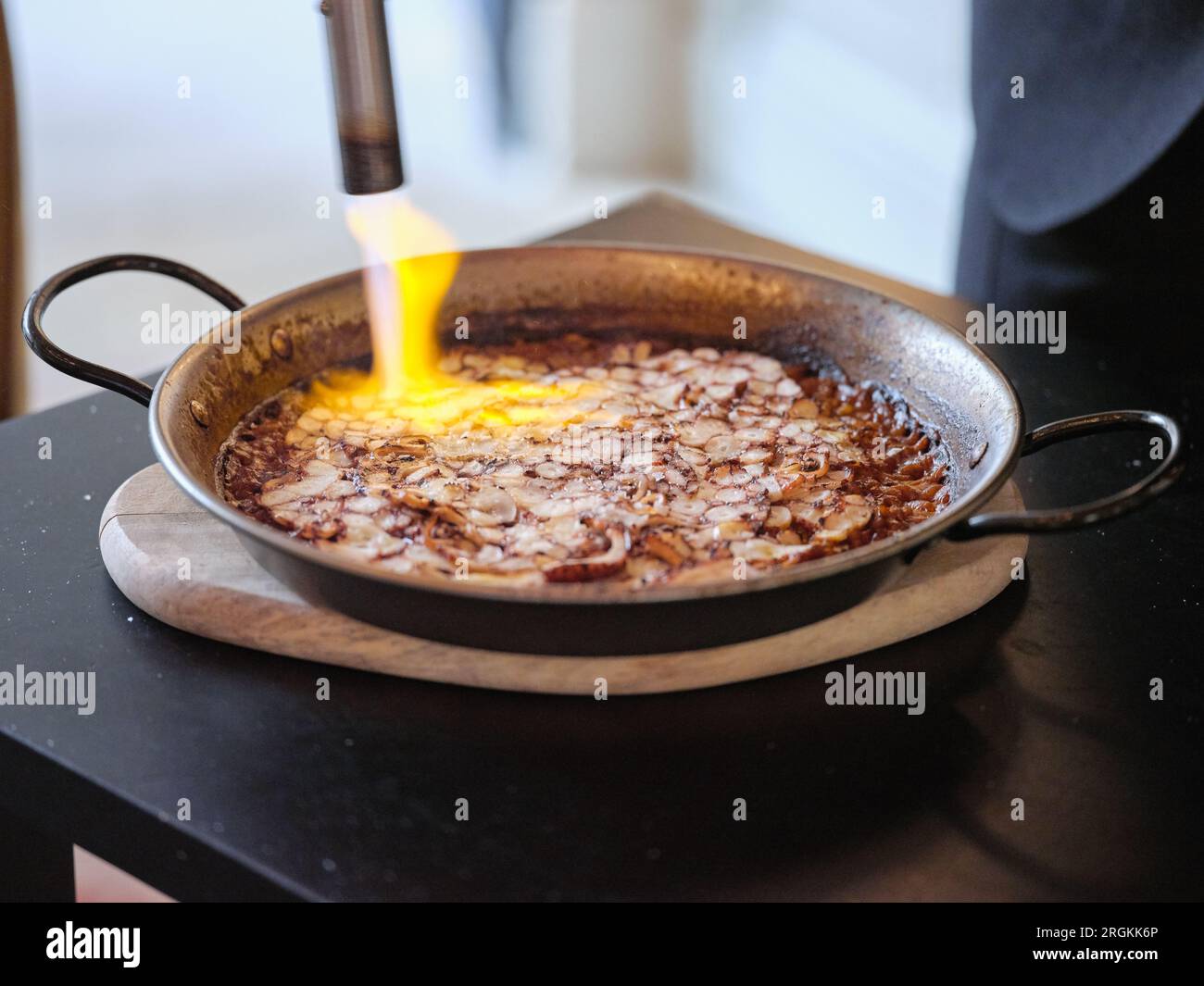 High angle of chef using cooking burner for cooking traditional paella ...