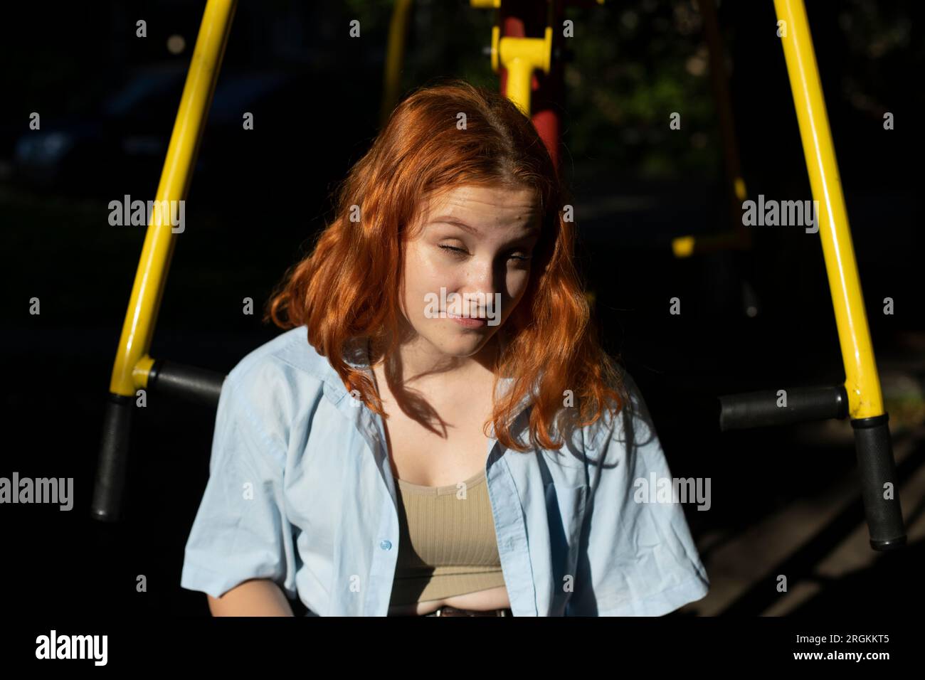 Girl makes stupid look. Sun hit eyes. Strange face. Red hair Stock ...