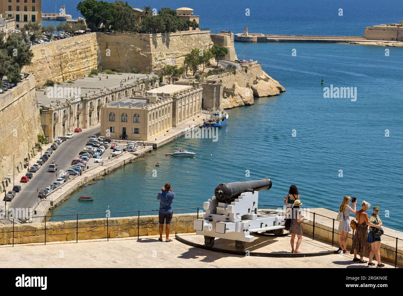 Valletta, Malta - 8 June 2023: Visitors alongside an old cannon on the ...
